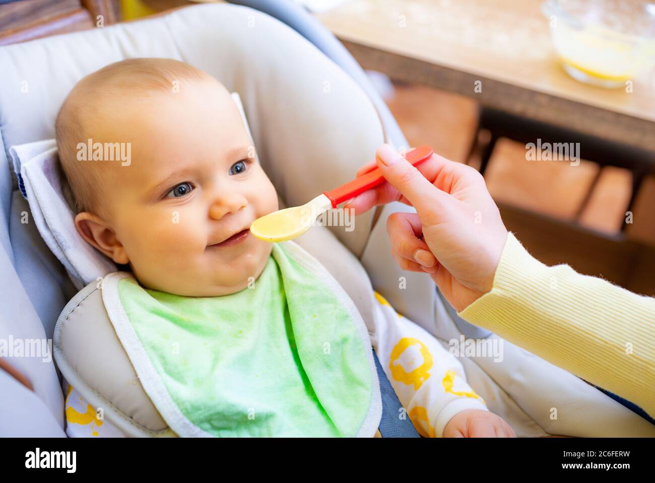 Unidentified mothers hand carefully feeds a cute healthy newborn girl ...