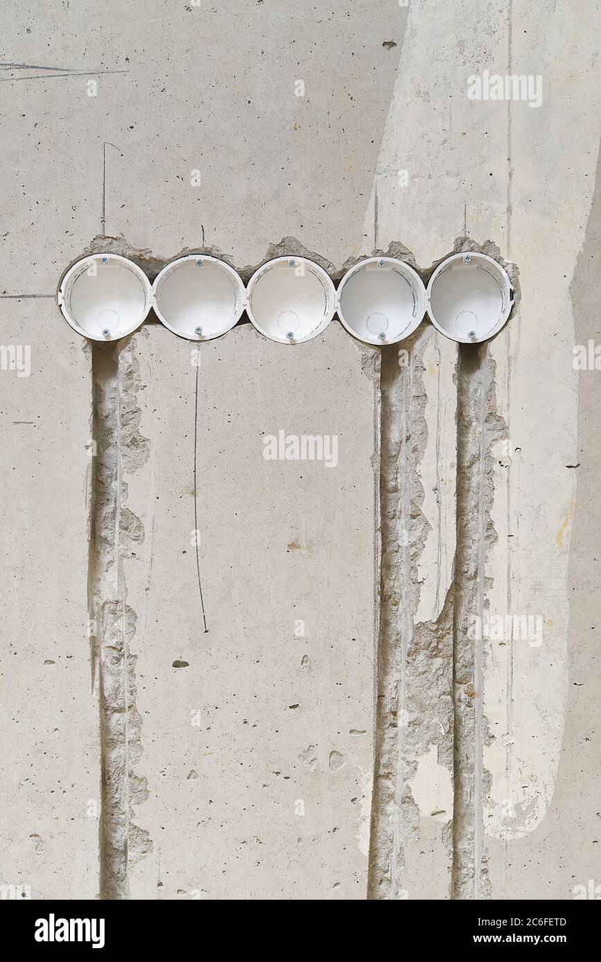 Holes in a concrete wall for installing plastic boxes under sockets ...