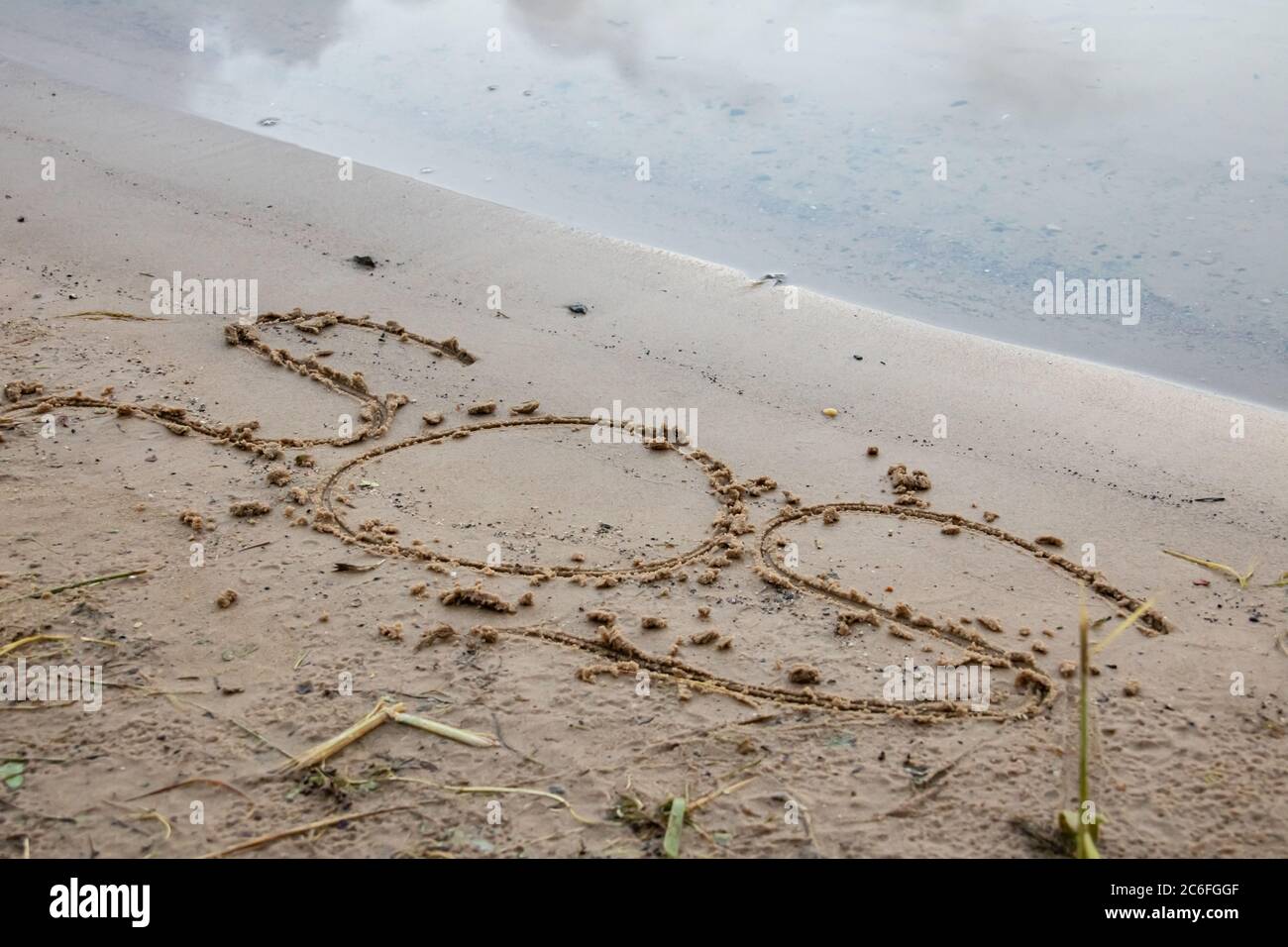 SOS letters in the sand on the beach Stock Photo - Alamy