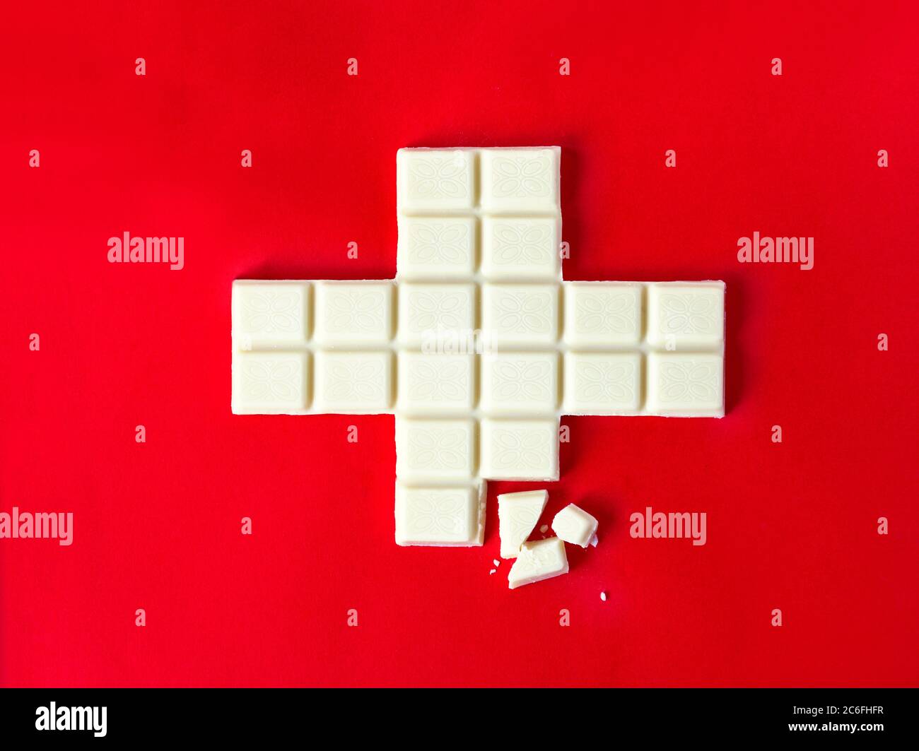 Swiss flag cross in form of white chocolate with some pieces over the ...