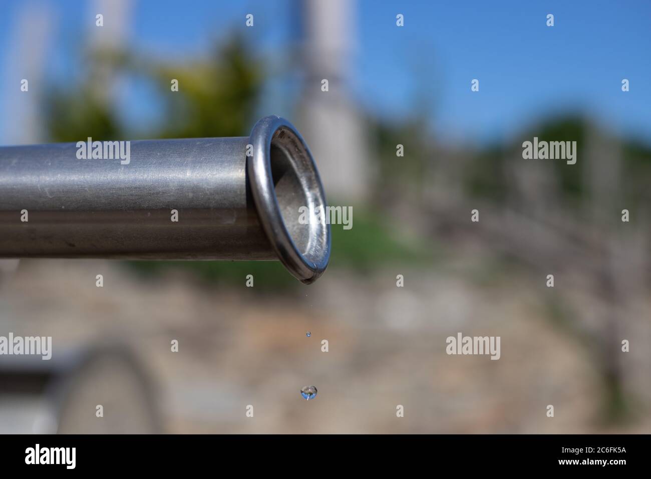 closeup of the last drop of water coming out a pipe simbolyzing draught ...