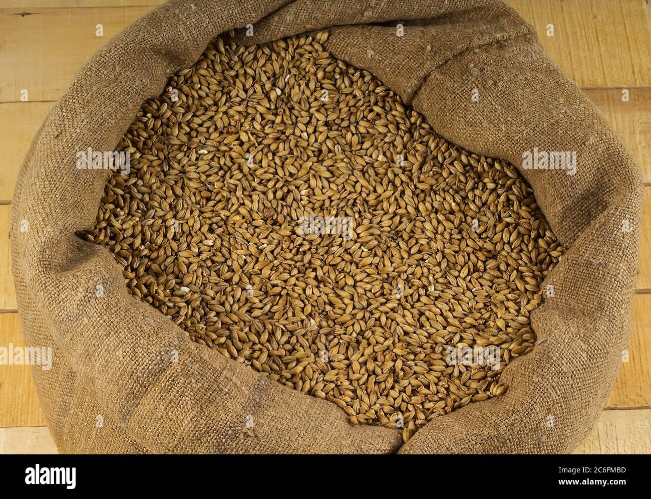 Bag of malt for the production of beer on wooden boards Stock Photo - Alamy