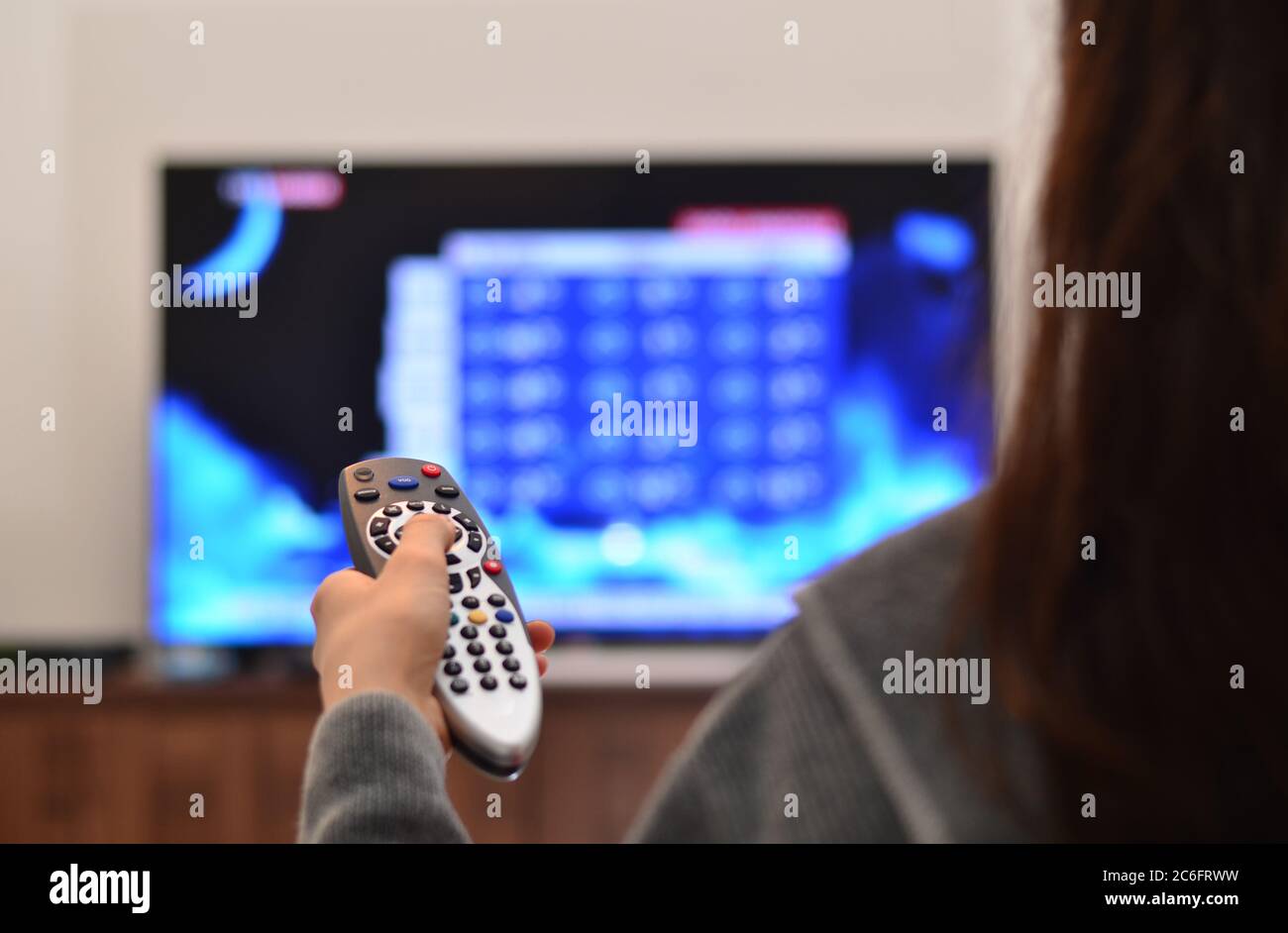 Women watching tv news and use remote controller Stock Photo - Alamy