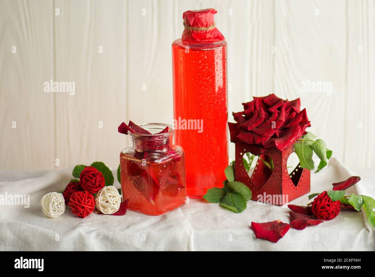 Perfumed rose water. Spa set with rose petals oil. Pink rose flower and ...