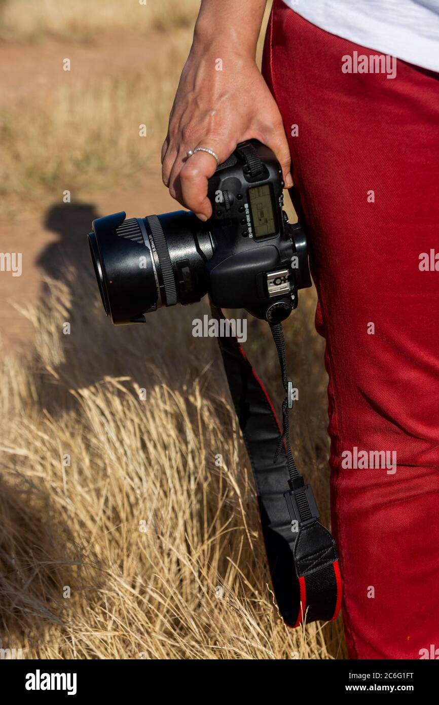 Photographer holding a camera in his hand Stock Photo - Alamy
