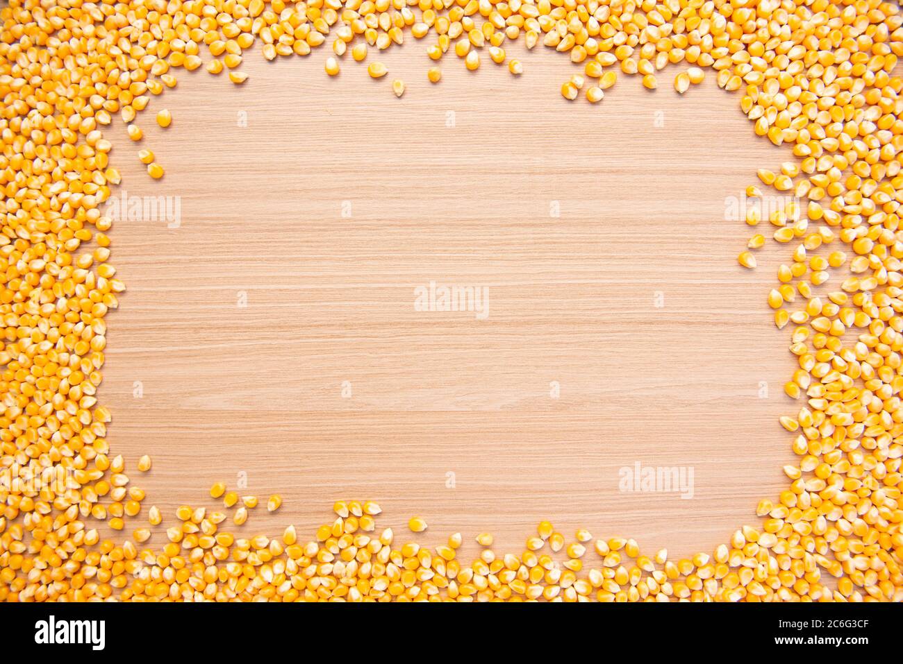 Frame created by grains of raw corn on wood. White space for text ...