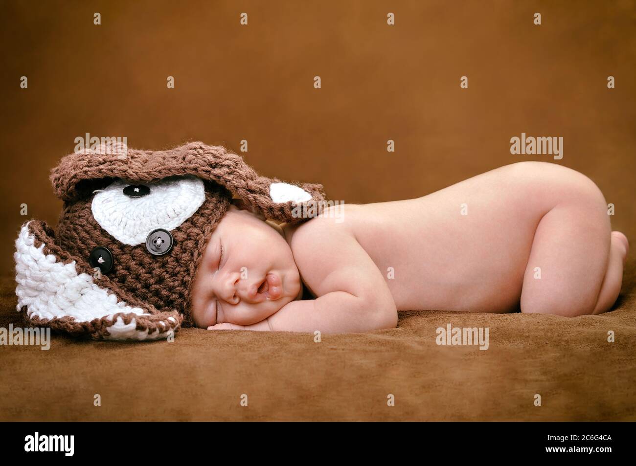 Beautiful newborn baby boy with cute cap sleeping peacefully on the soft brown blanket Stock ...