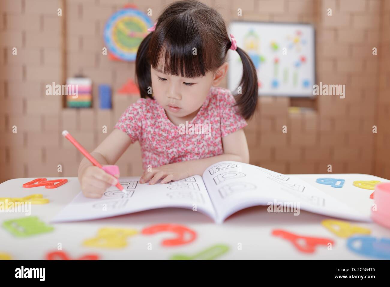 toddler girl practice writing letters for homeschooling Stock Photo - Alamy