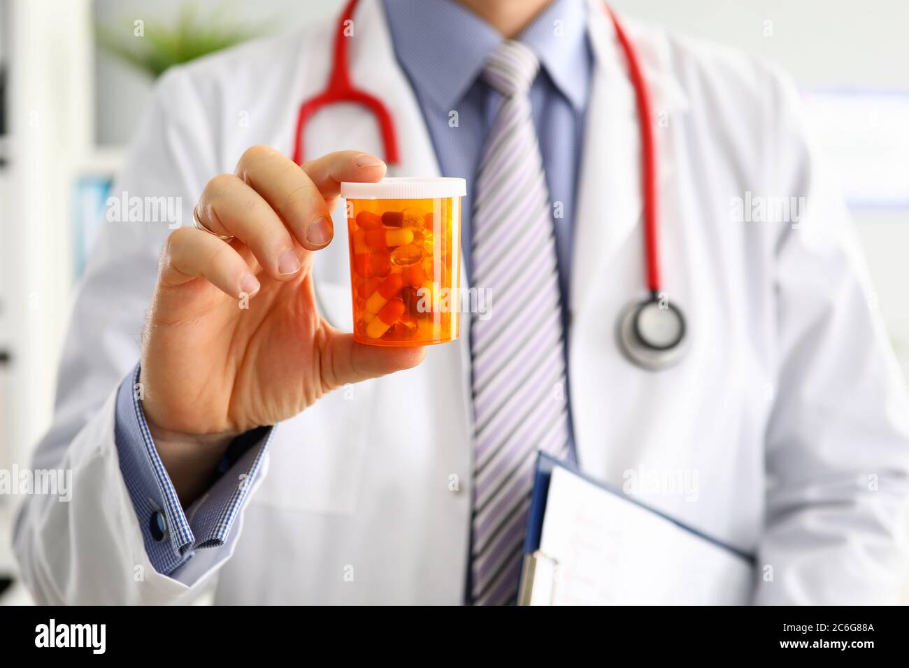 Male medicine doctor hand holding and offering to patient jar of pills ...