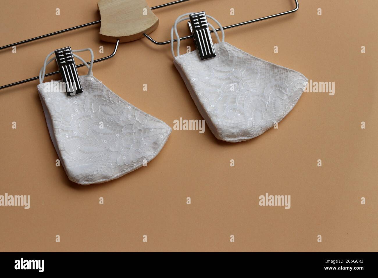 White color of lace reusable face masks hanging on clothes hanger ...