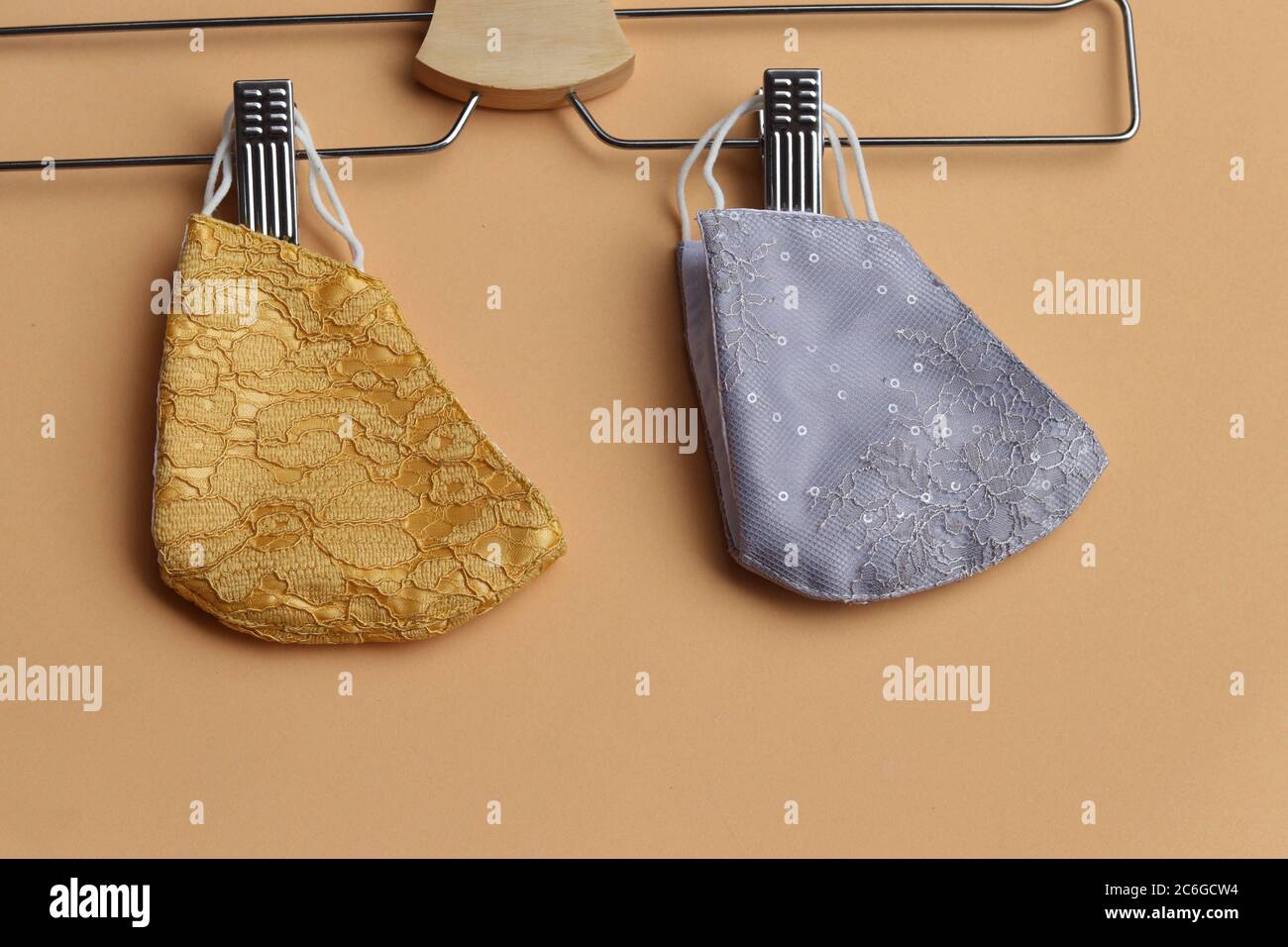 Gold and silver lace reusable face masks hanging on clothes hanger ...