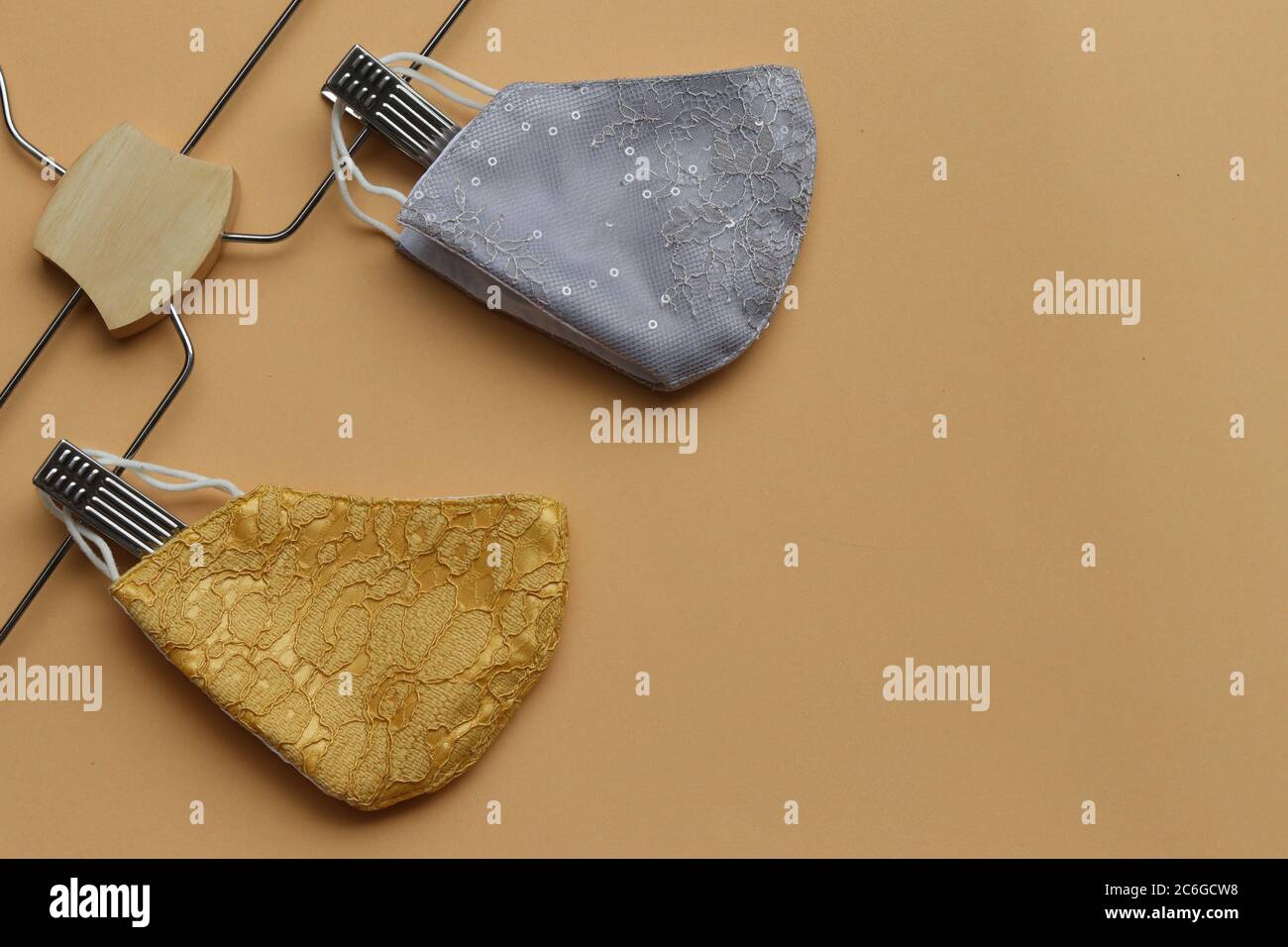 Gold and silver lace reusable face masks hanging on clothes hanger ...