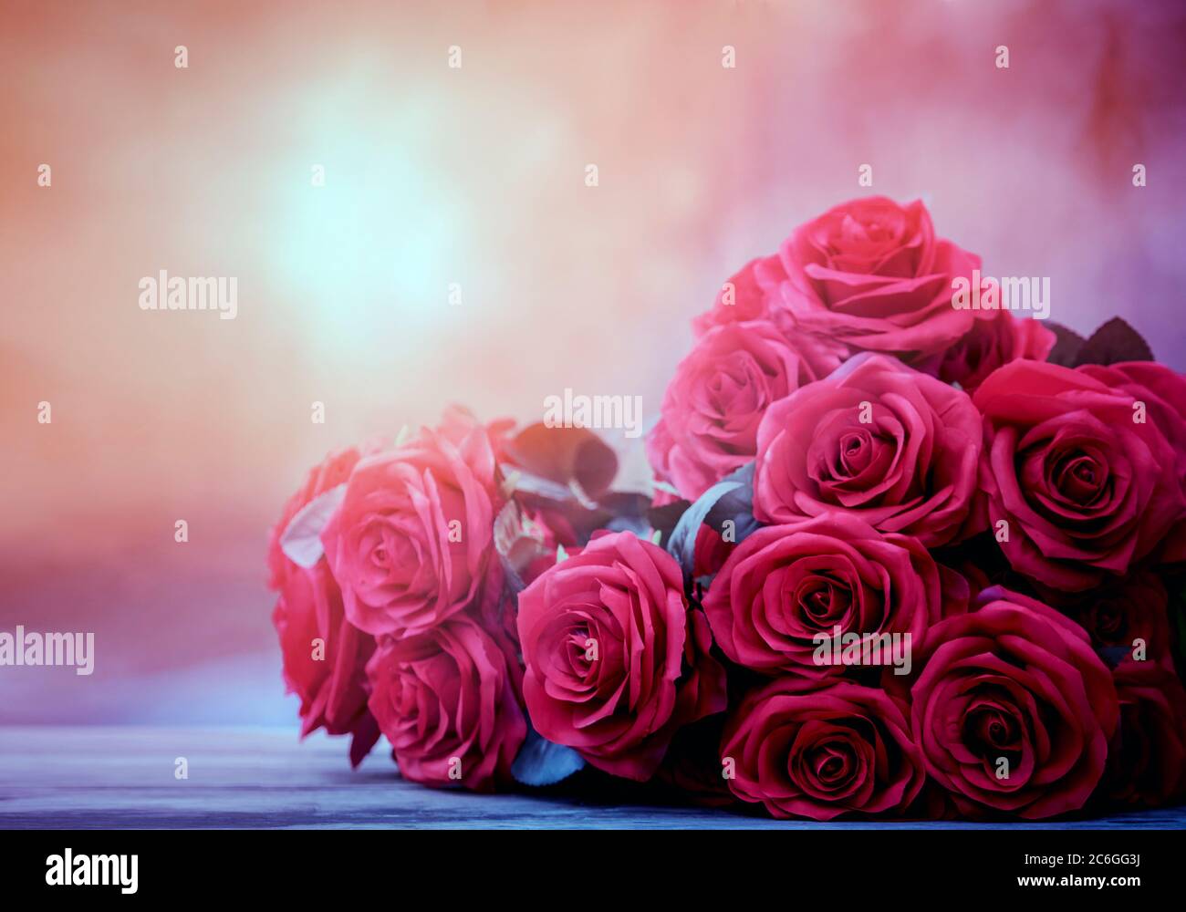 red roses bouquet on wood floor against colorful blur background Stock ...