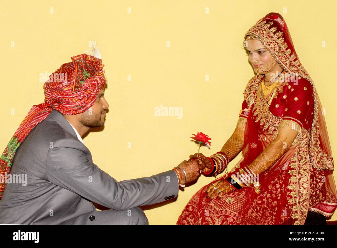 Indian groom proposing to his bride to giving rose in traditional dress ...