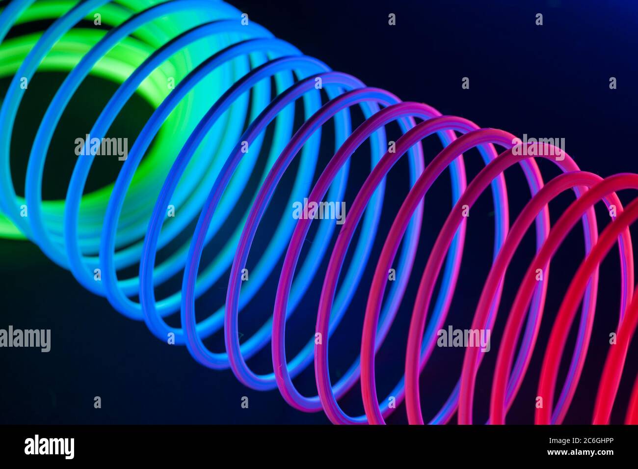 Multi-colored circular spiral objects are viewed in close and lit with ...