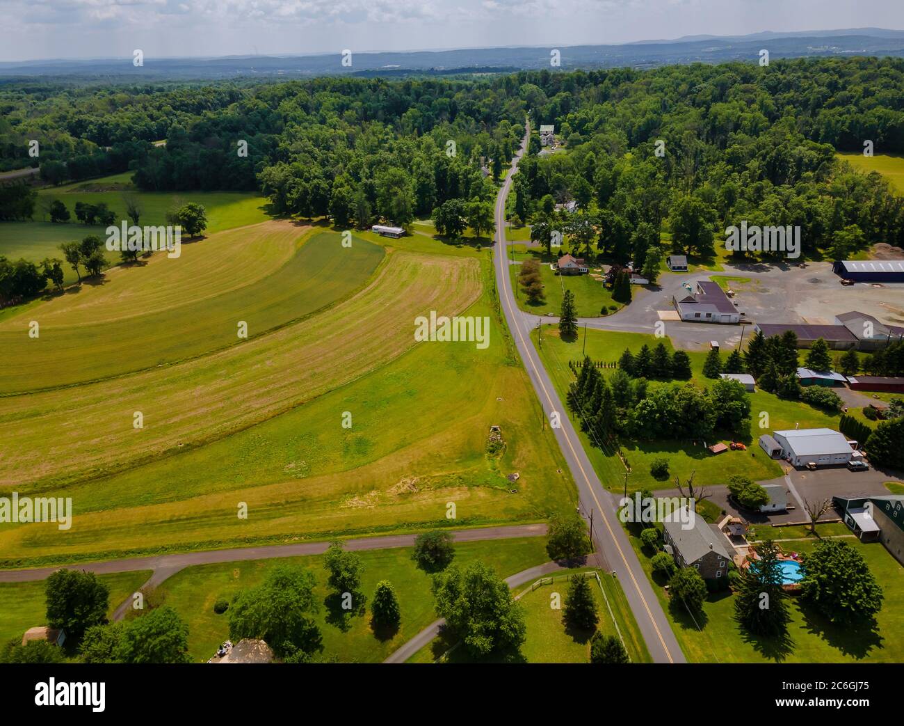 Aerial view from the heights of a countryside village with fields green ...