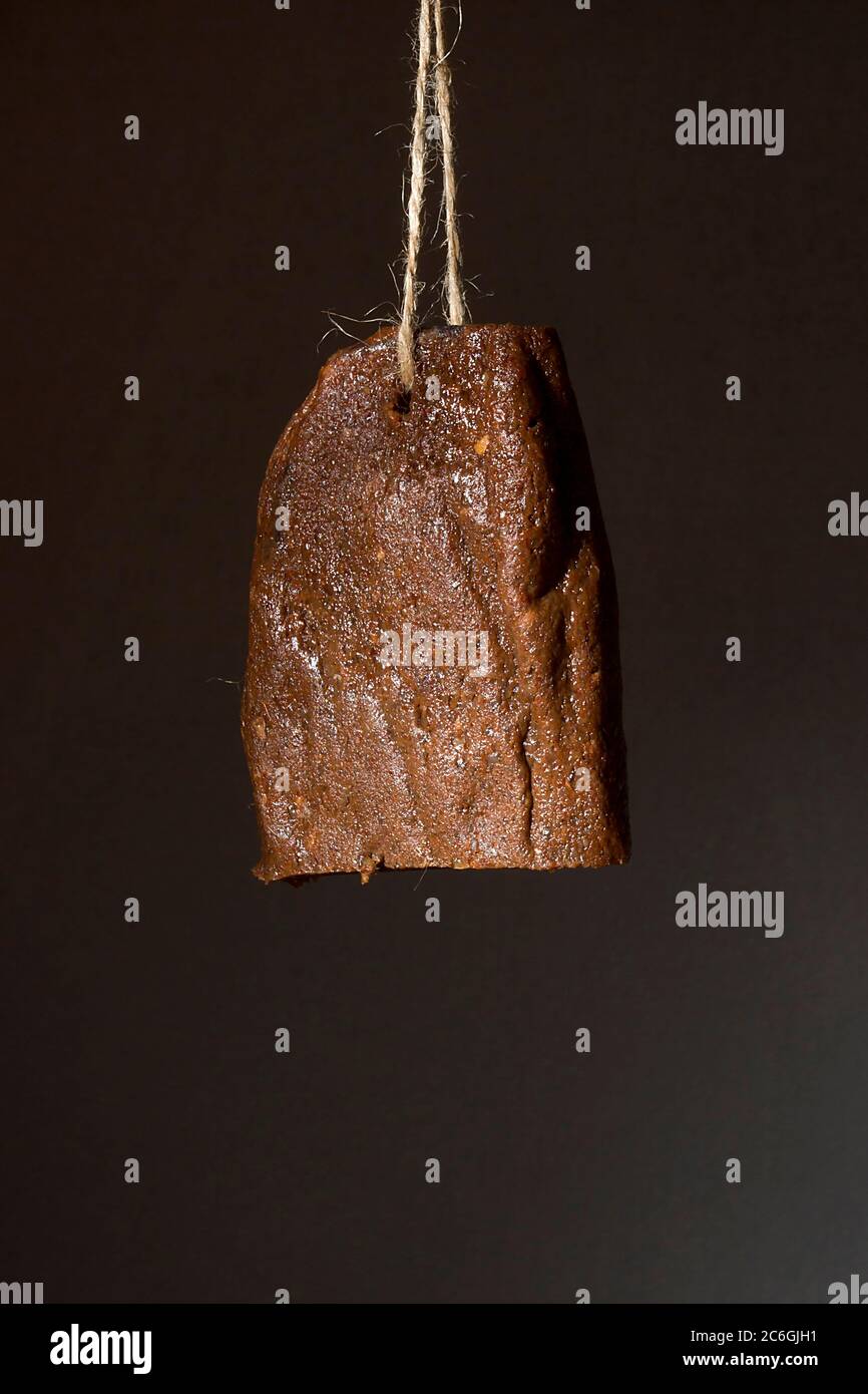 Jerky beef hanging on a rope against a black wall Stock Photo - Alamy