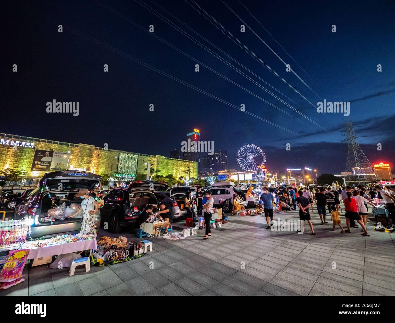 People walk and shop around at a 7-day temporary night market in ...
