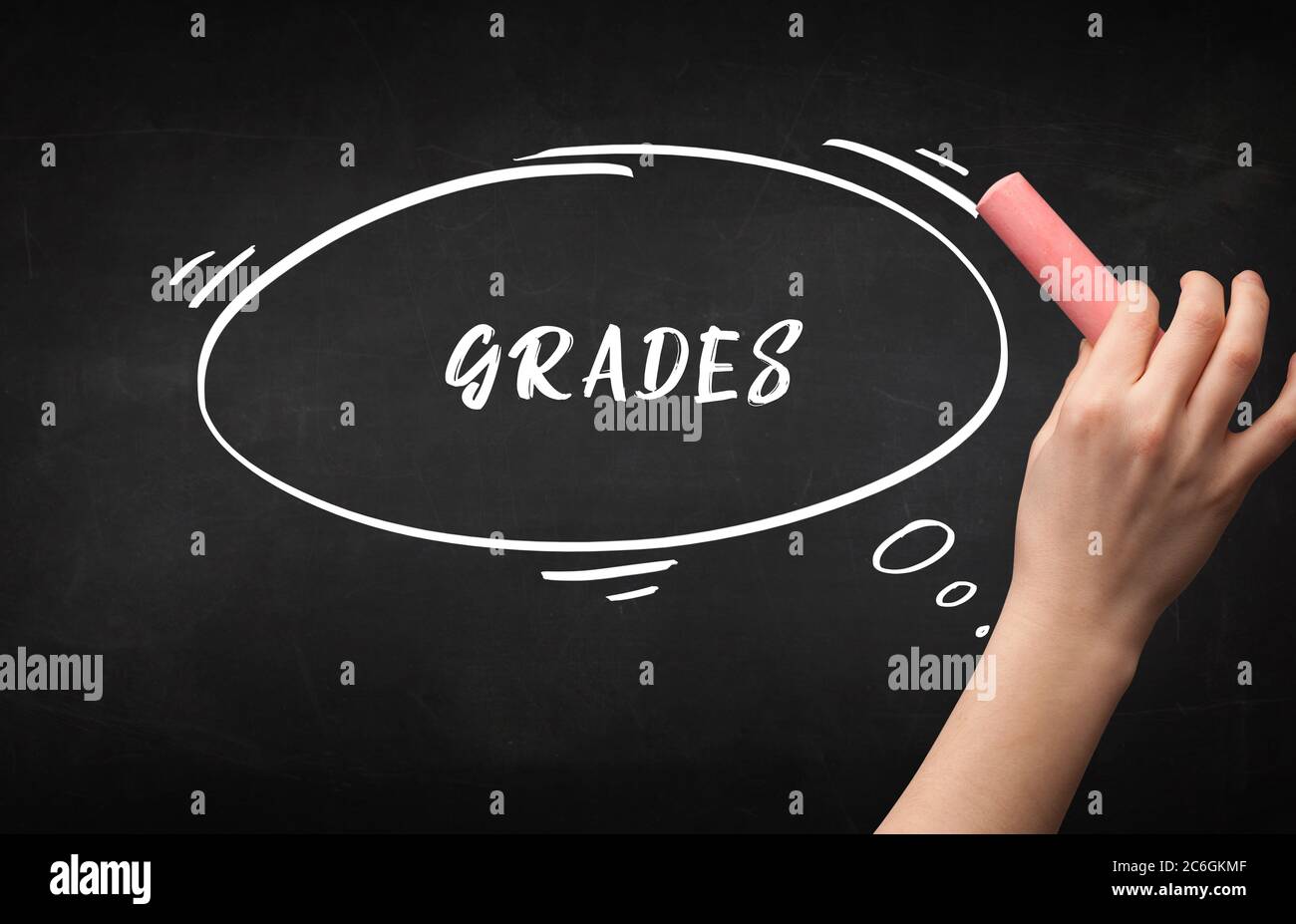 Hand drawing GRADES inscription with white chalk on blackboard ...