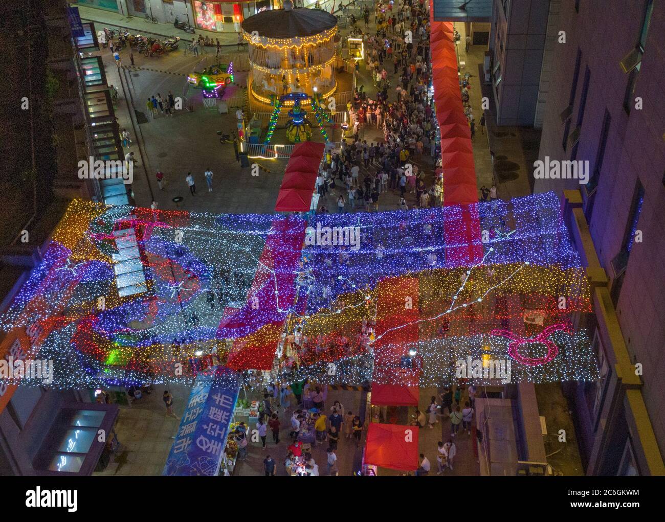 Aerial view of a night market decorated with colorful LED lights that ...
