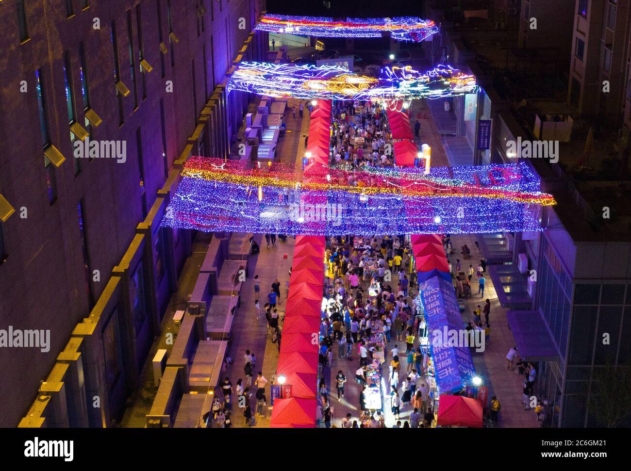 Aerial view of a night market decorated with colorful LED lights that ...