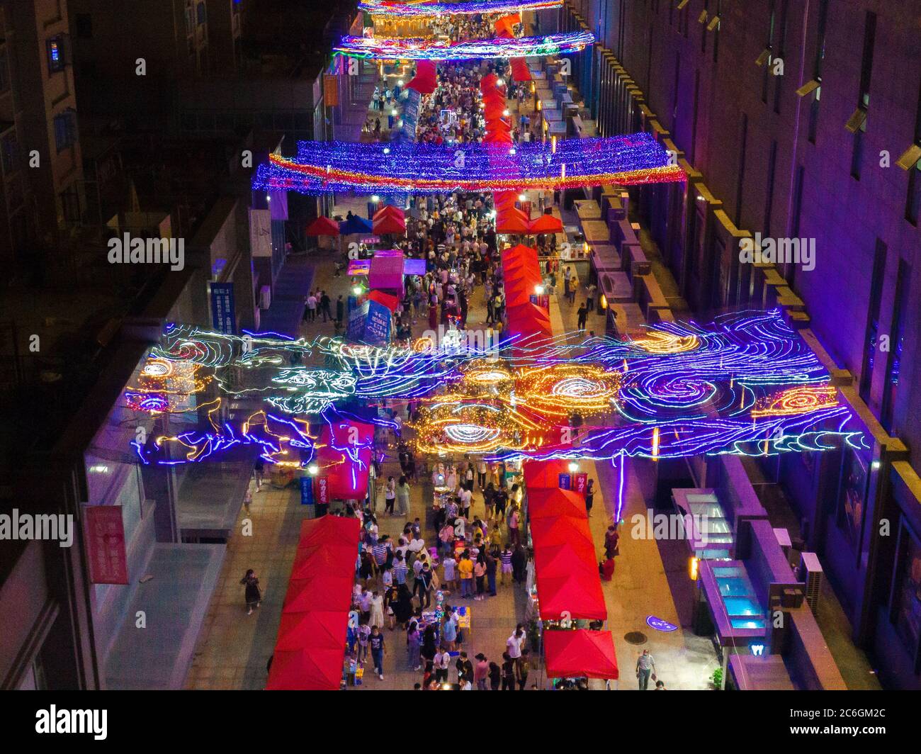 Aerial view of a night market decorated with colorful LED lights that ...