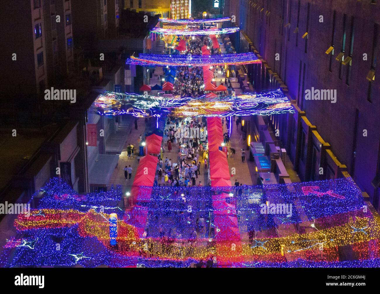 Aerial view of a night market decorated with colorful LED lights that ...