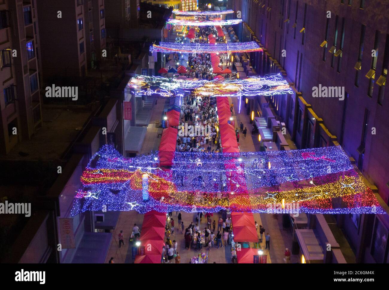 Aerial view of a night market decorated with colorful LED lights that ...