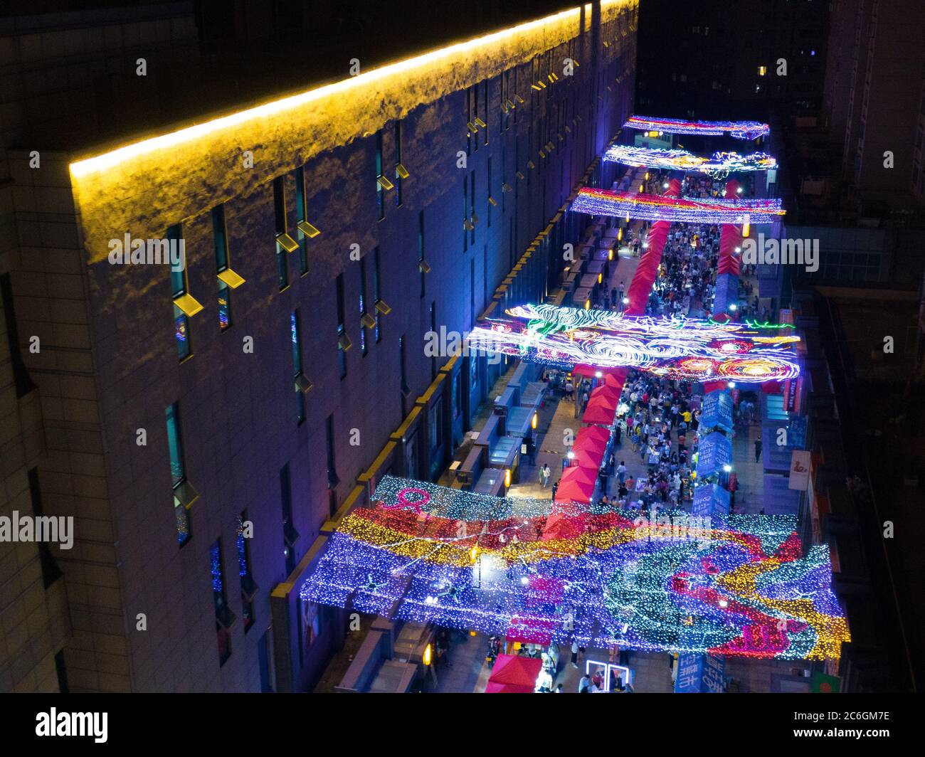 Aerial view of a night market decorated with colorful LED lights that ...