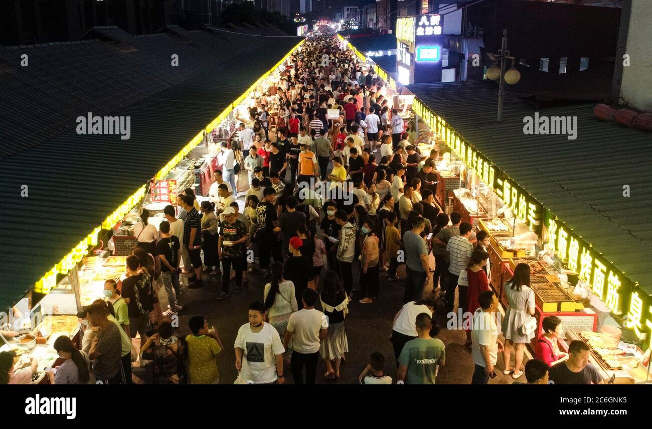 Customers are seen crowding on the street, along which vendors and ...