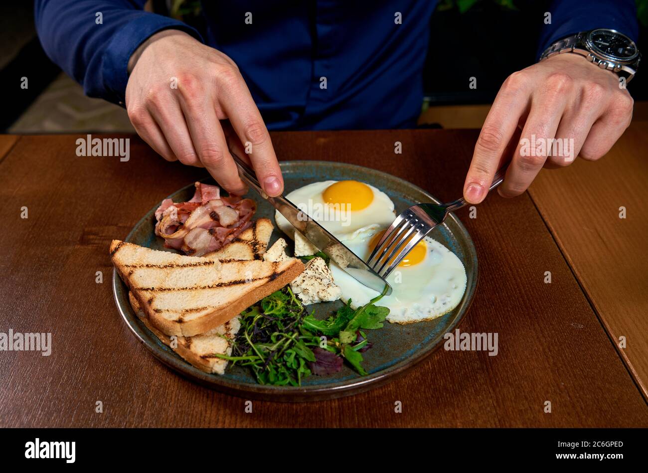 a man eats eggs in a restaurant Stock Photo - Alamy