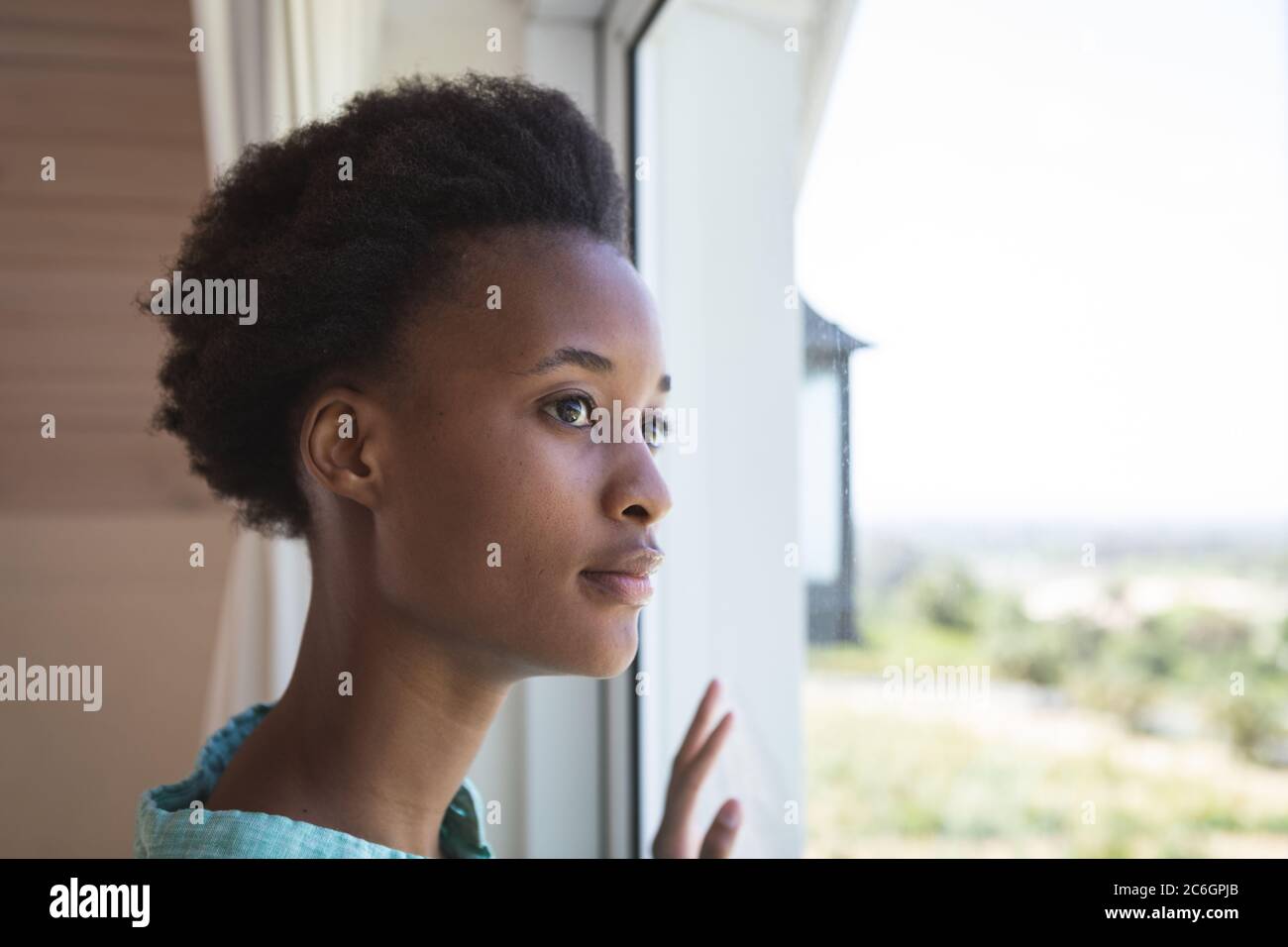 Woman looking out of the window Stock Photo - Alamy