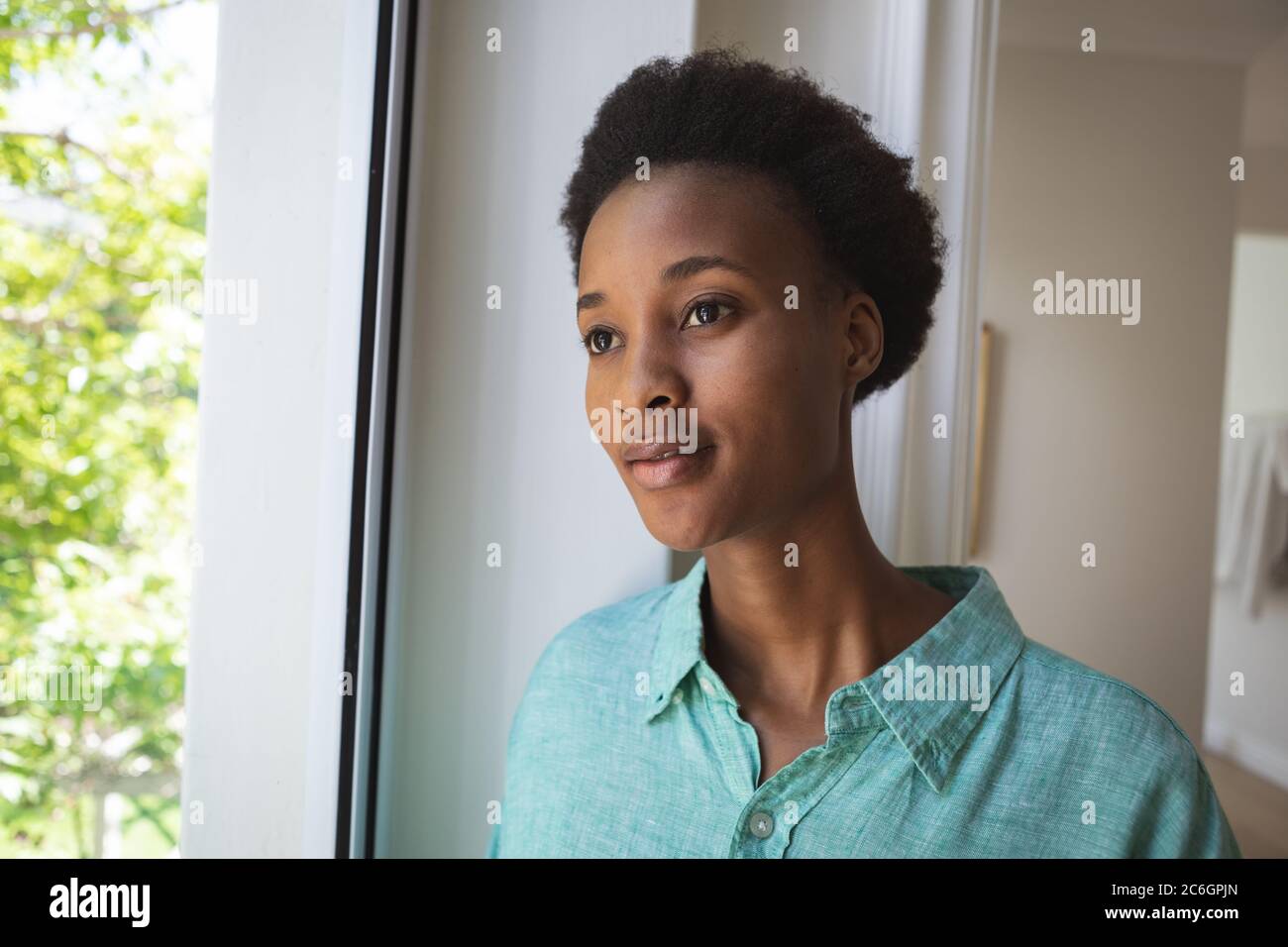 Woman looking out of the window Stock Photo - Alamy