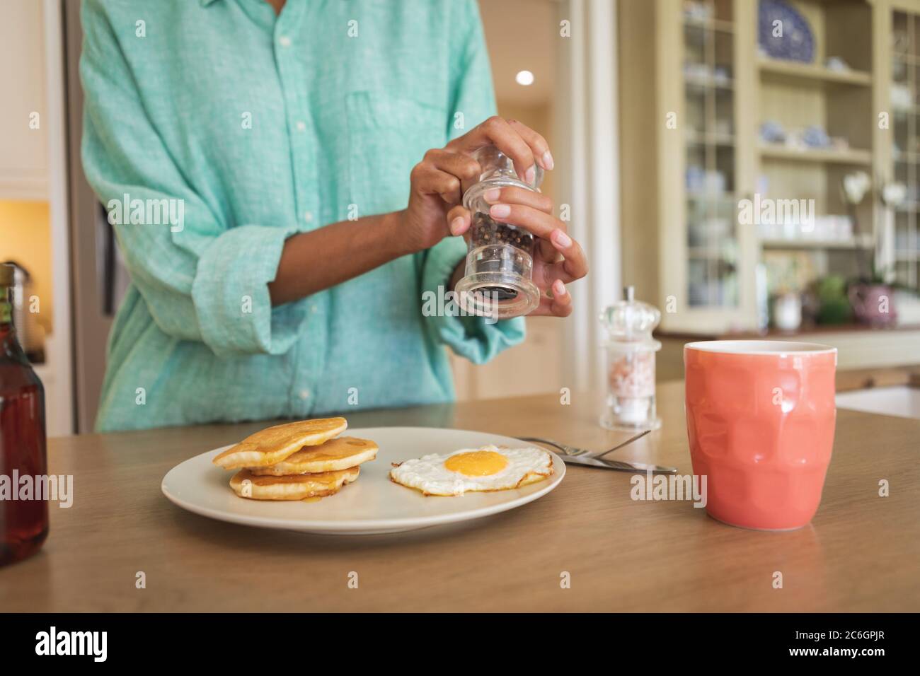 Mid section of woman putting salt on cooked eggs Stock Photo - Alamy