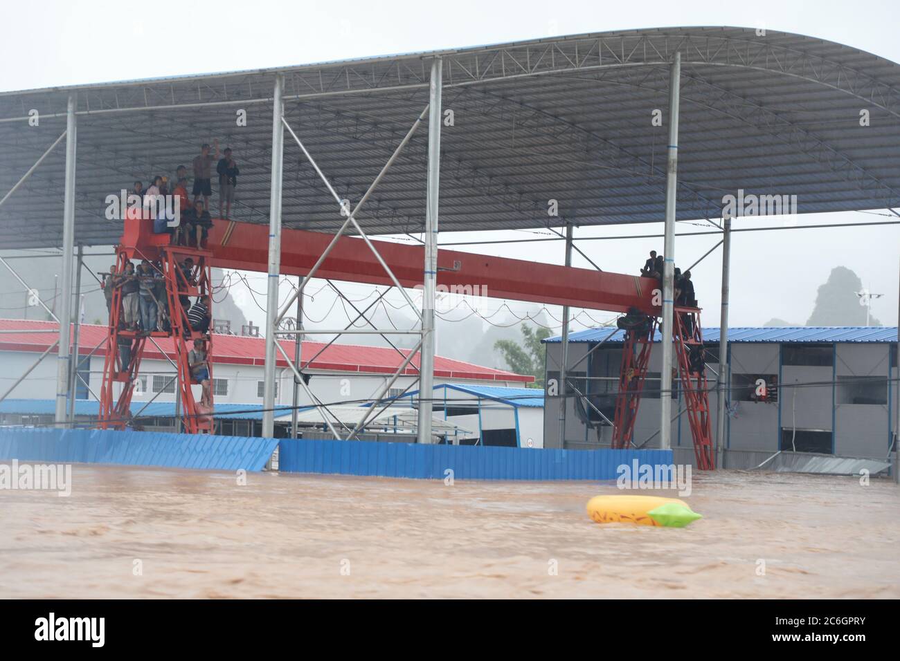People climb up a staircase to avoid flood caused by heavy rain in a ...