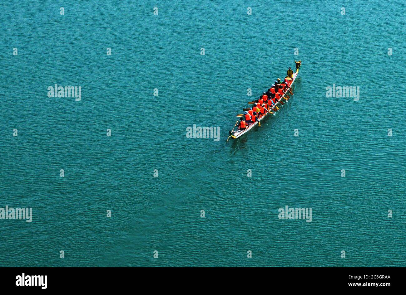 An aerial view of a group of men busy at practicing rowing a dragon ...