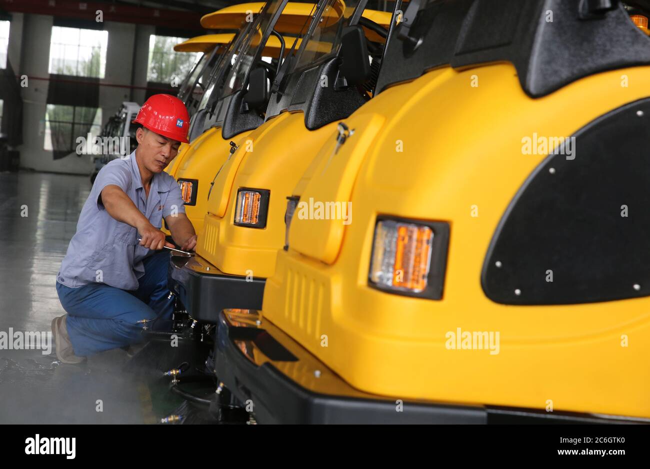 Local workers are busy at testing fortlifts at a machinery factory ...