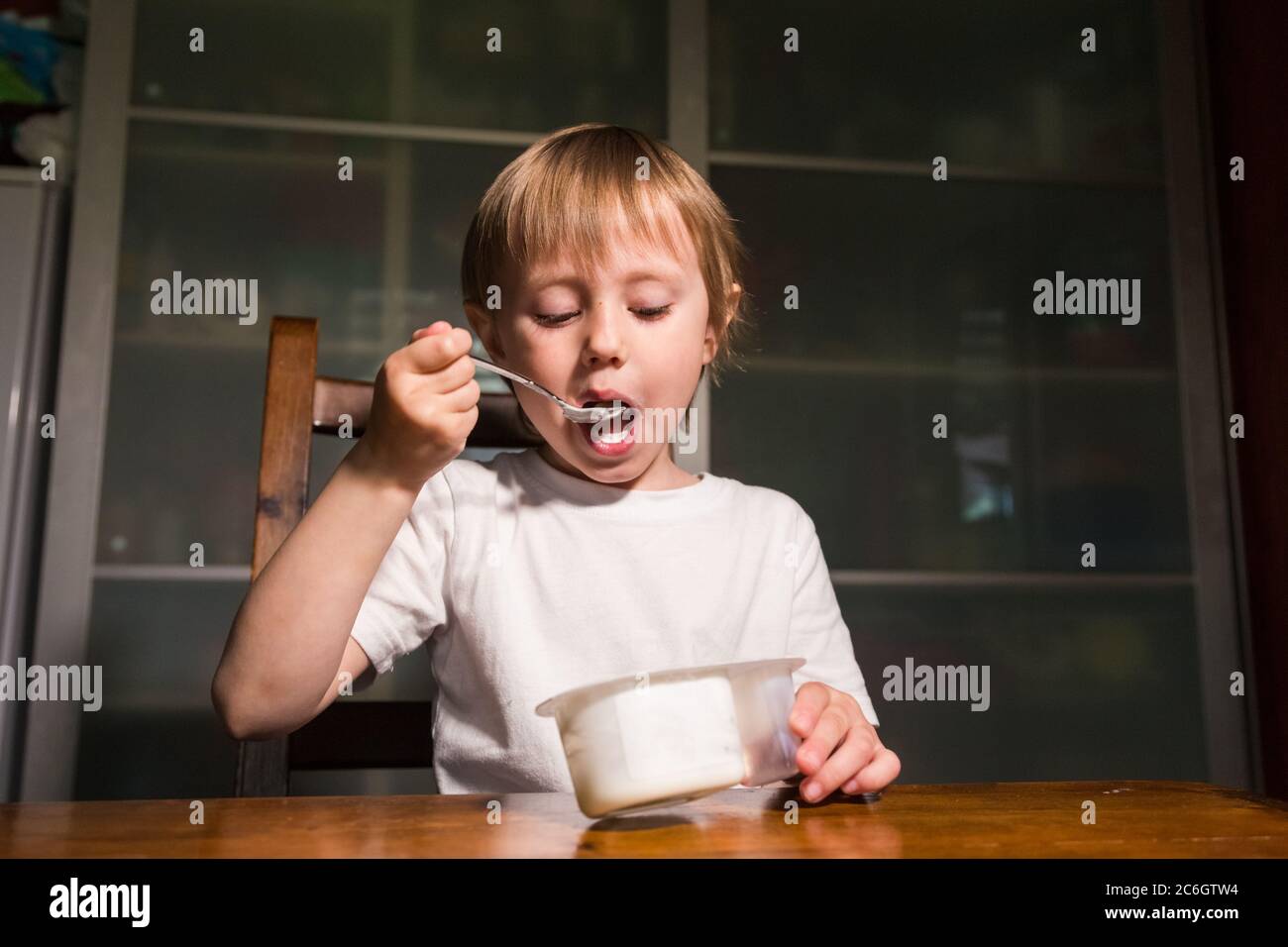 Adorable baby girl eating cottage cheese from spoon, healthy milk snack ...