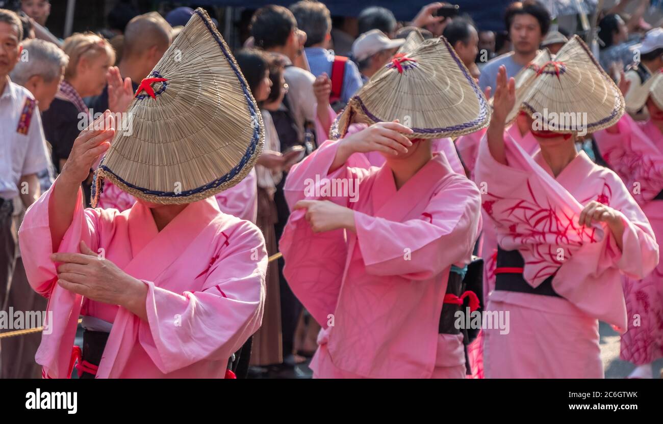 Folk dancers in colorful yukata and amigasa straw hat dancing in ...