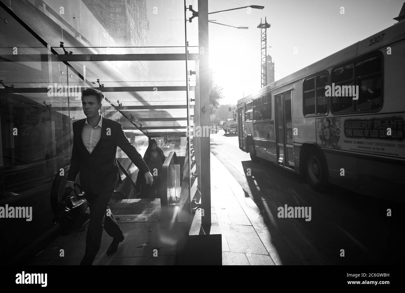 Street photography. A professional man gets off the the escalator from ...