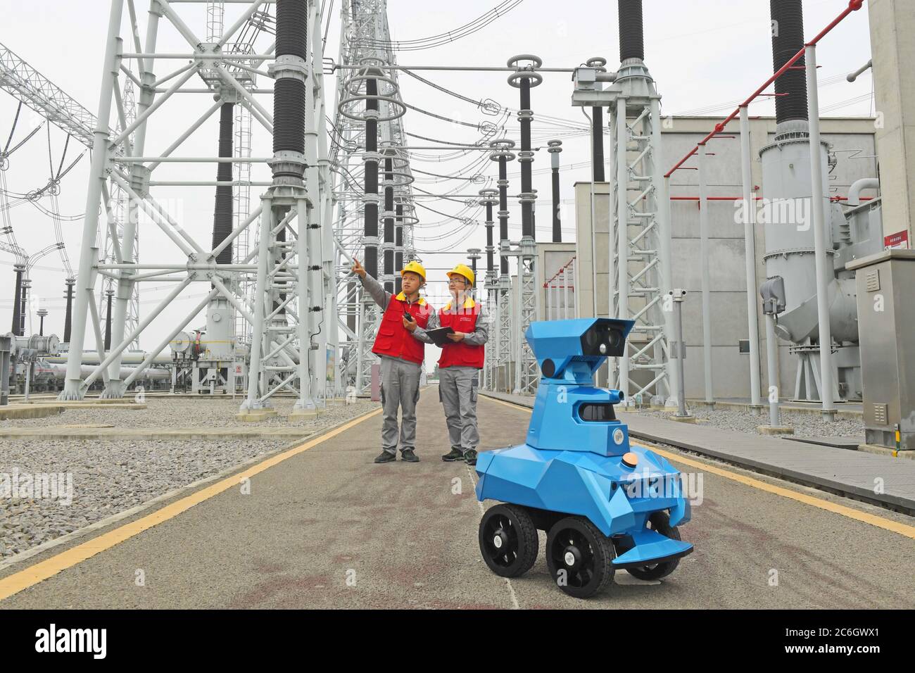 Assisted by robots, staff patrol along equipment to ensure summer ...