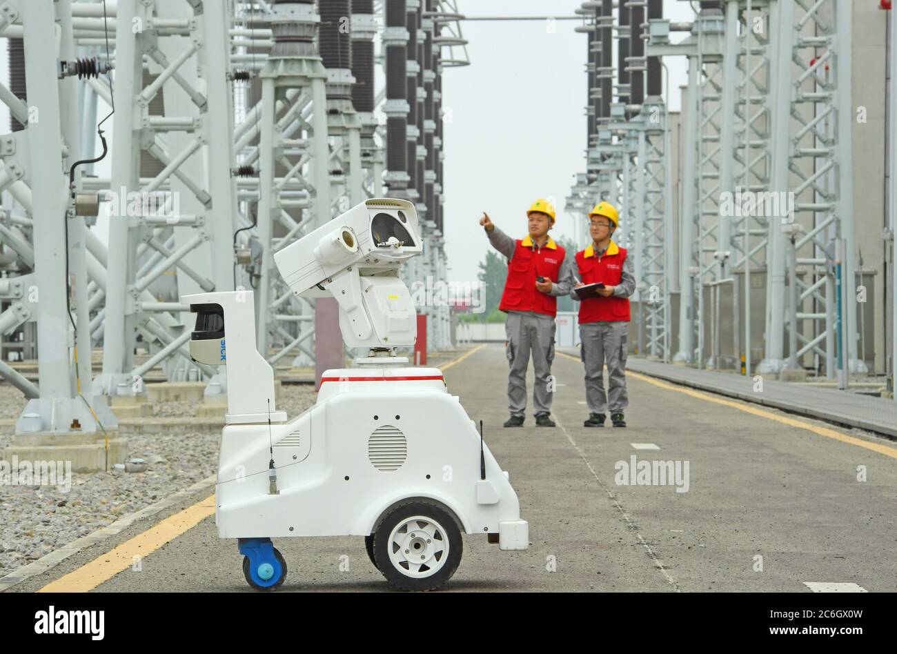 Assisted by robots, staff patrol along equipment to ensure summer ...