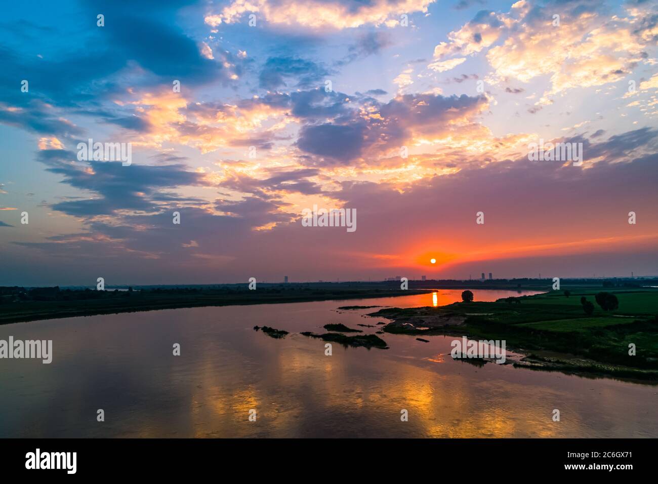 Sunset paints the skyline into golden yellow and purple after a ...