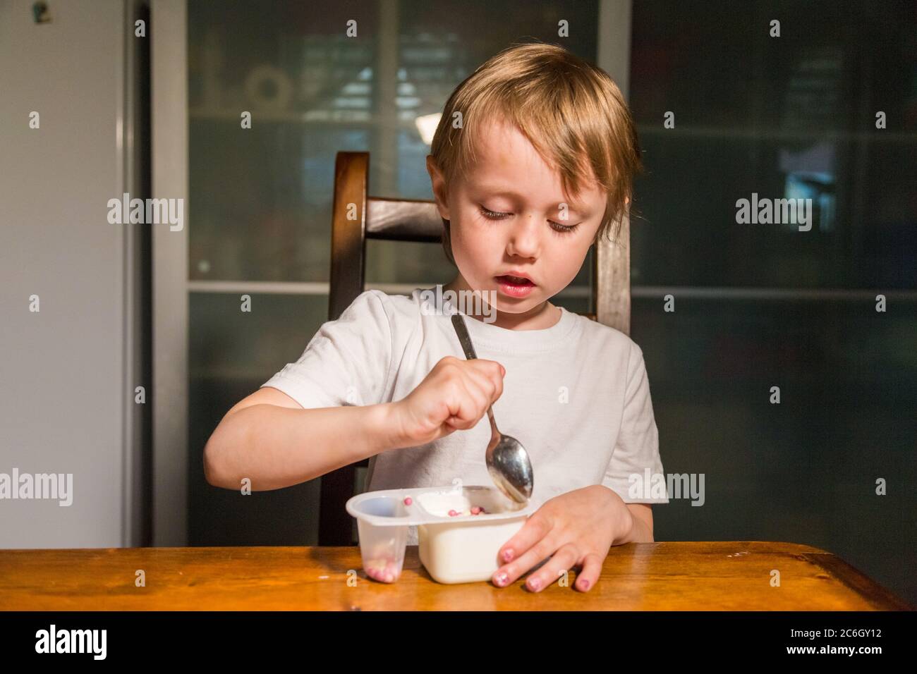 Adorable baby girl eating cottage cheese from spoon, healthy milk snack ...