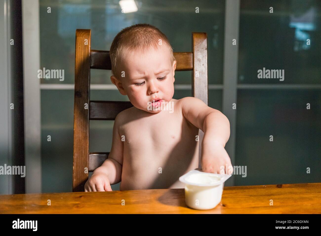 Adorable baby boy eating cottage cheese from spoon, healthy milk snack ...