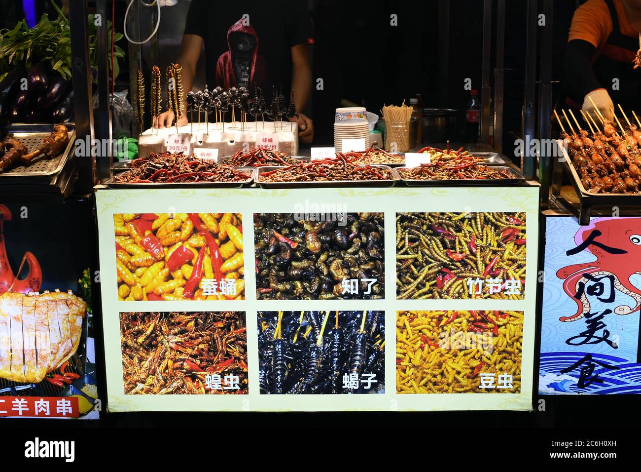 A vendor sells deep fried insects including silkworm pupa, cicada ...