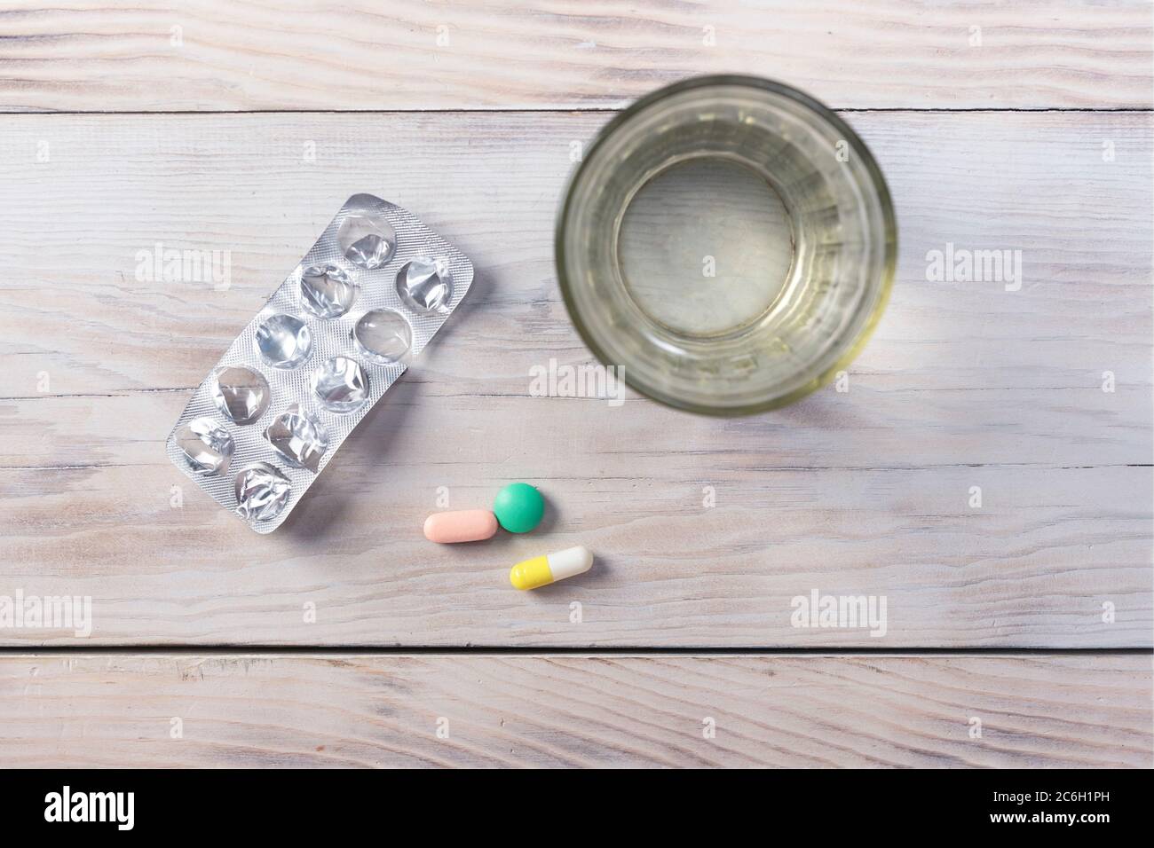 Daily doses of tablets for patients for each day on wood table ...