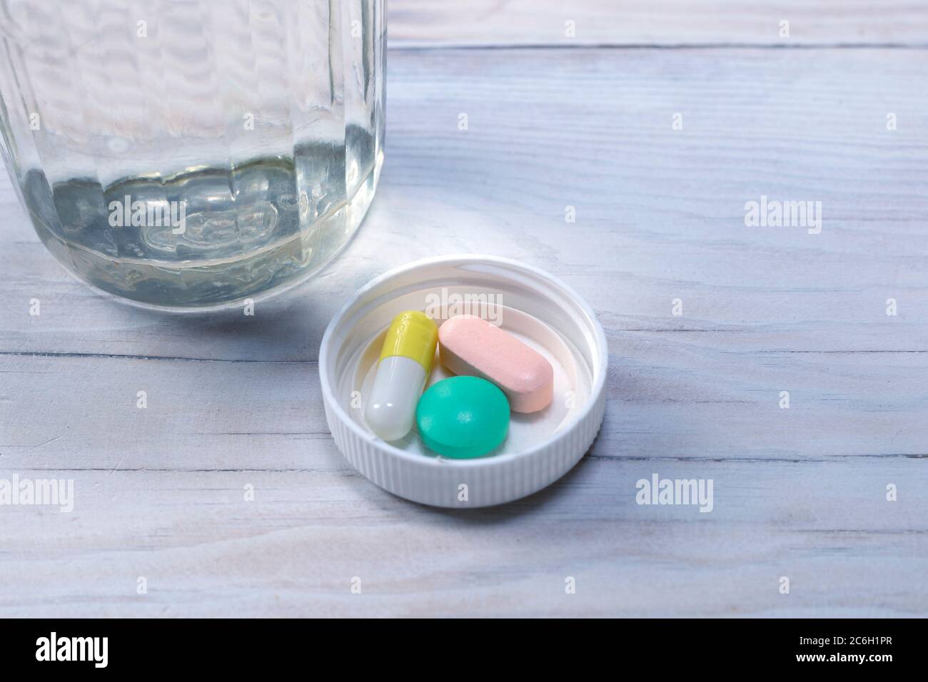 Daily doses of tablets for patients for each day on wood table ...