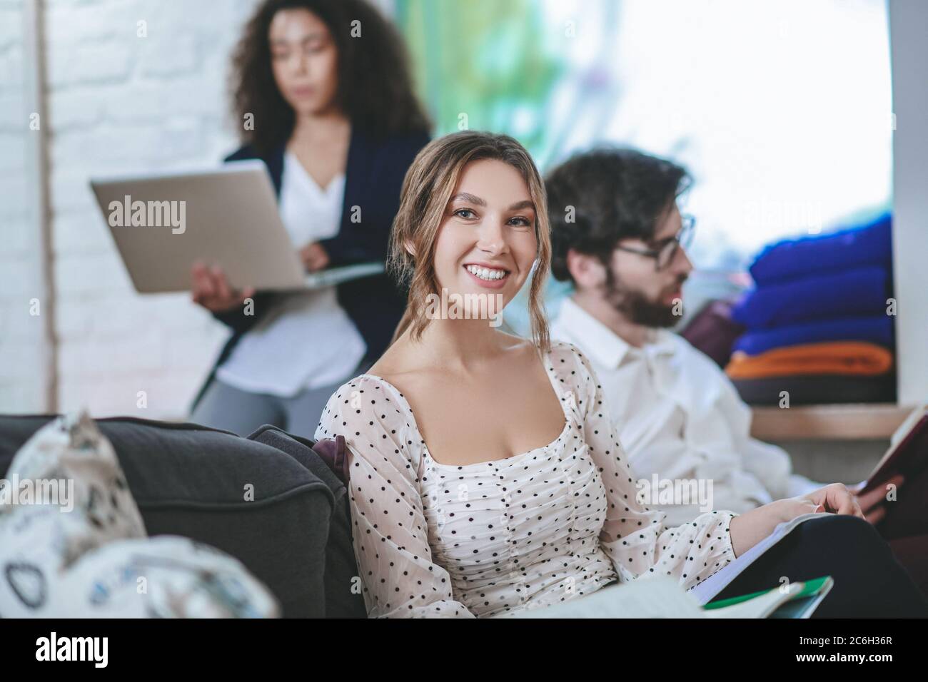 Joyful girl with white-toothed smile on couch, boyfriend and girlfriend ...