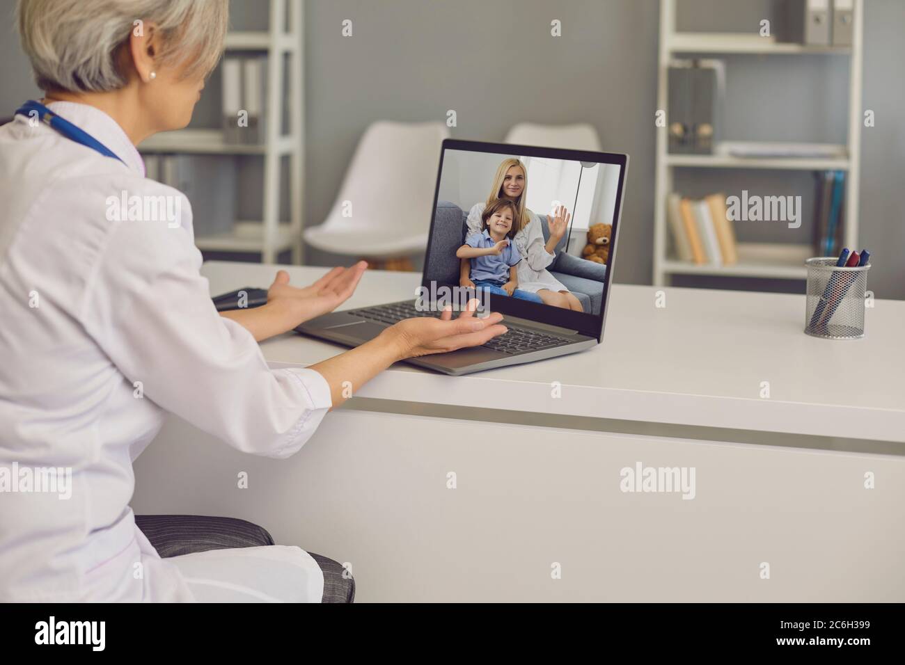 Doctor online. Mother with child speaks with doctors remotely using ...